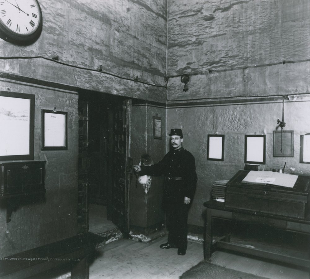 A Prison Warder Stands by a Door in the Entrance Hall