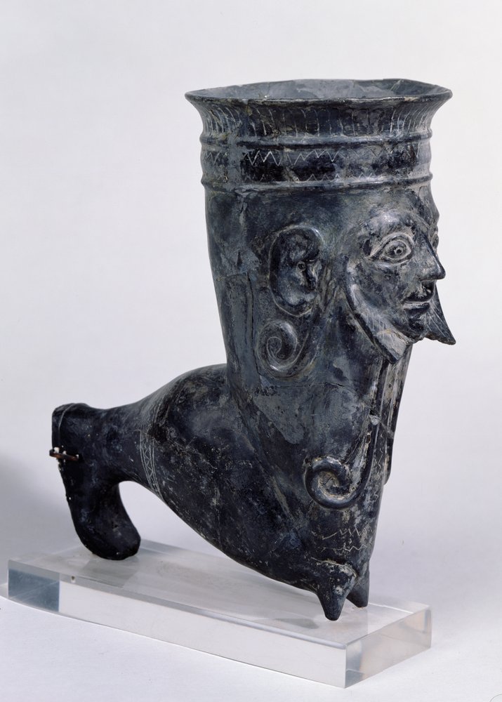 Bucchero vessel in the form of a leg with sculpted face, Etruscan ...