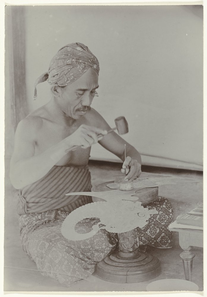Javanese Man Creating a Human-Like Figure with Hammer and Instruments