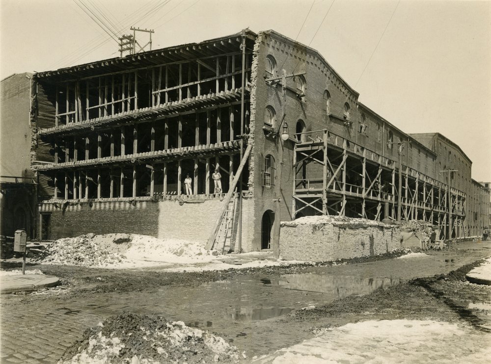 Construction Site, Two Men Standing in Open Side of Warehouse Building ...