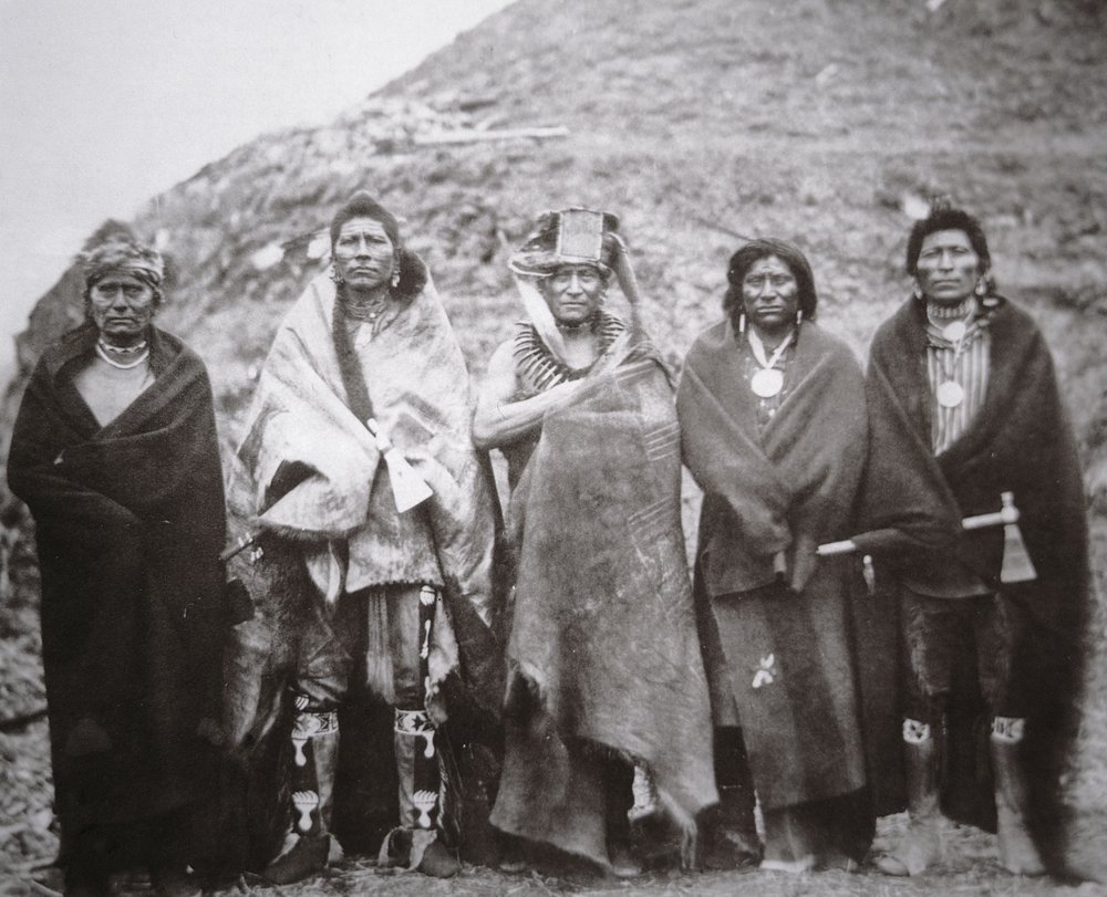 Pawnee people in front of a tribal earth lodge