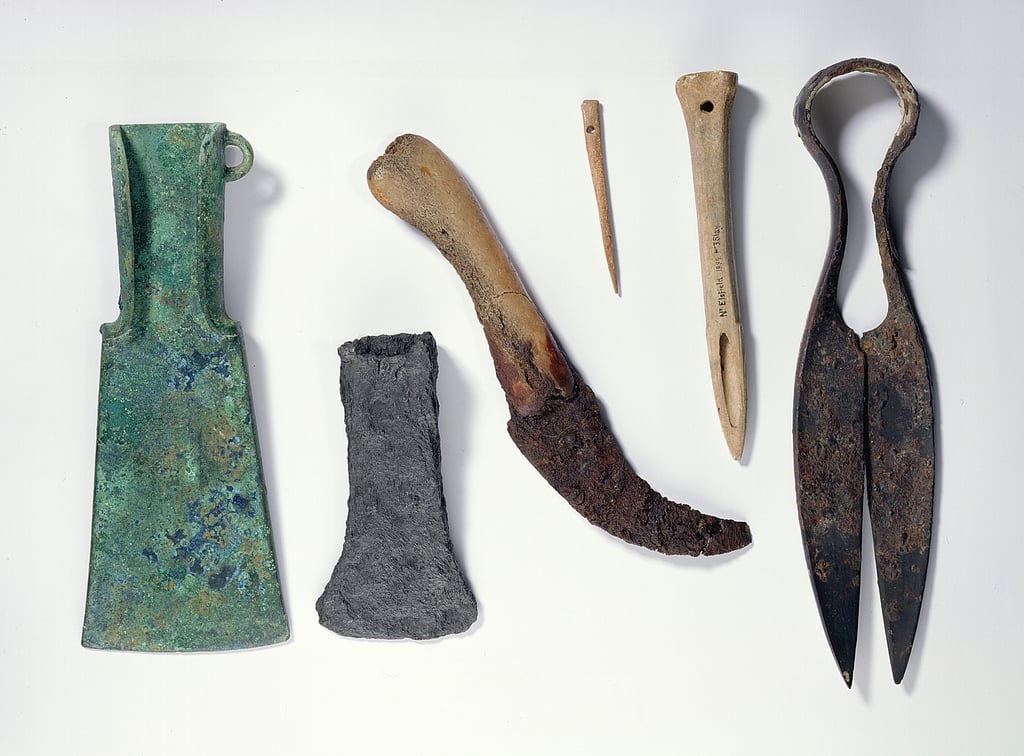 Selection of tools: L-R: early Iron Age bronze axe with bent-over wings ...