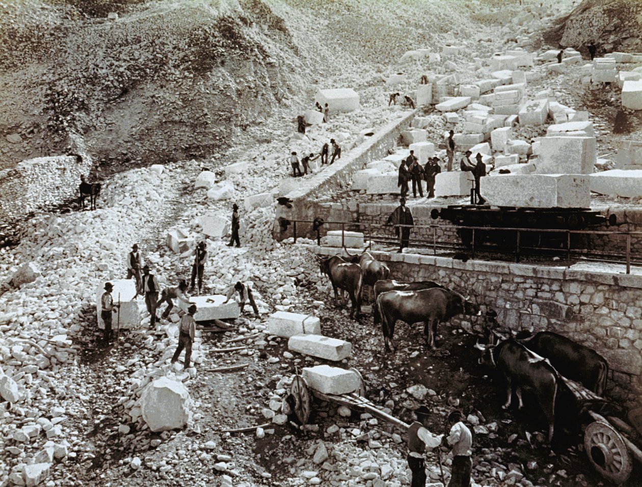 Railway station with laborers loading marble blocks onto railway wagons ...