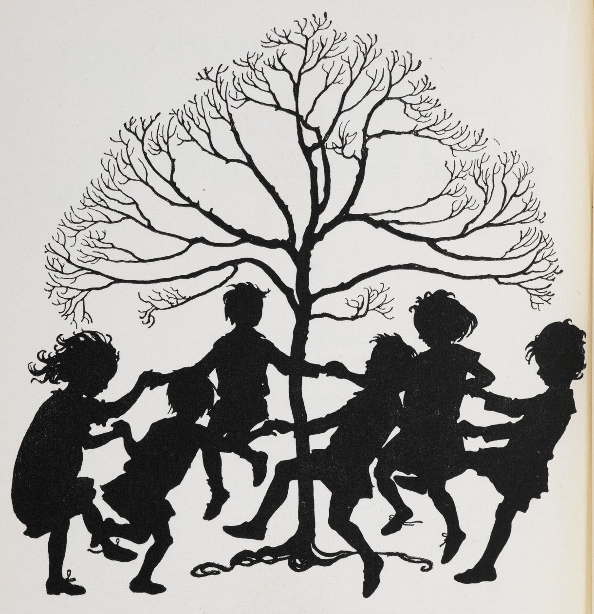 Silhouette of children dancing around a tree