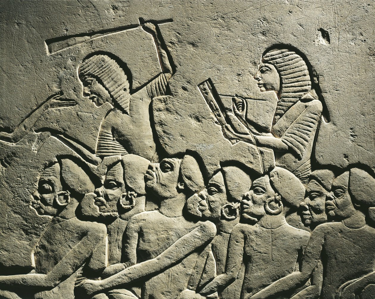 Negroid prisoners surrounded by guards armed with clubs while a scribe ...