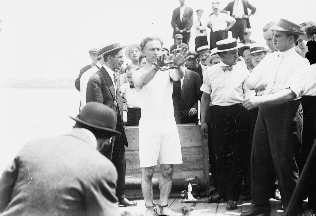 Harry Houdini being handcuffed before being nailed into a crate and ...