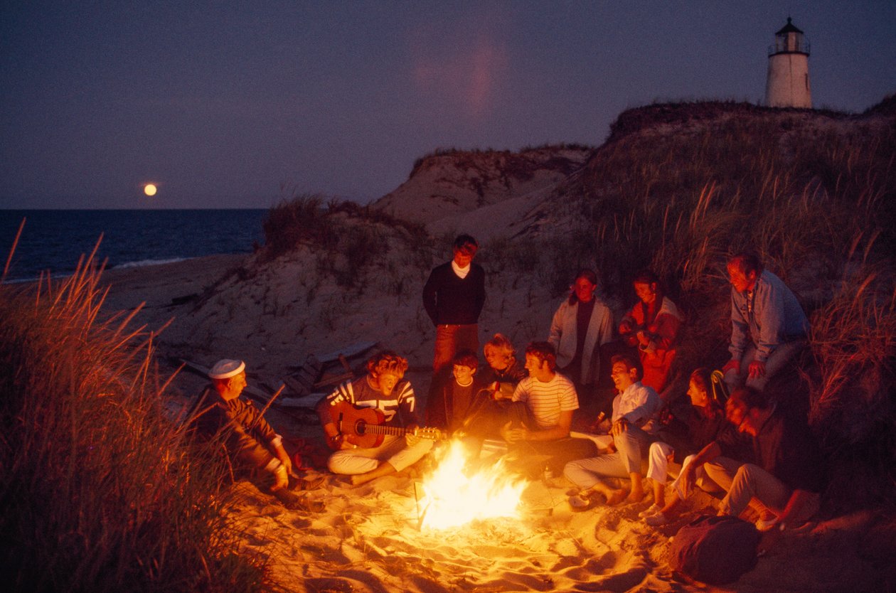 Friends gather around a summer campfire at Great Point Lighthouse ...