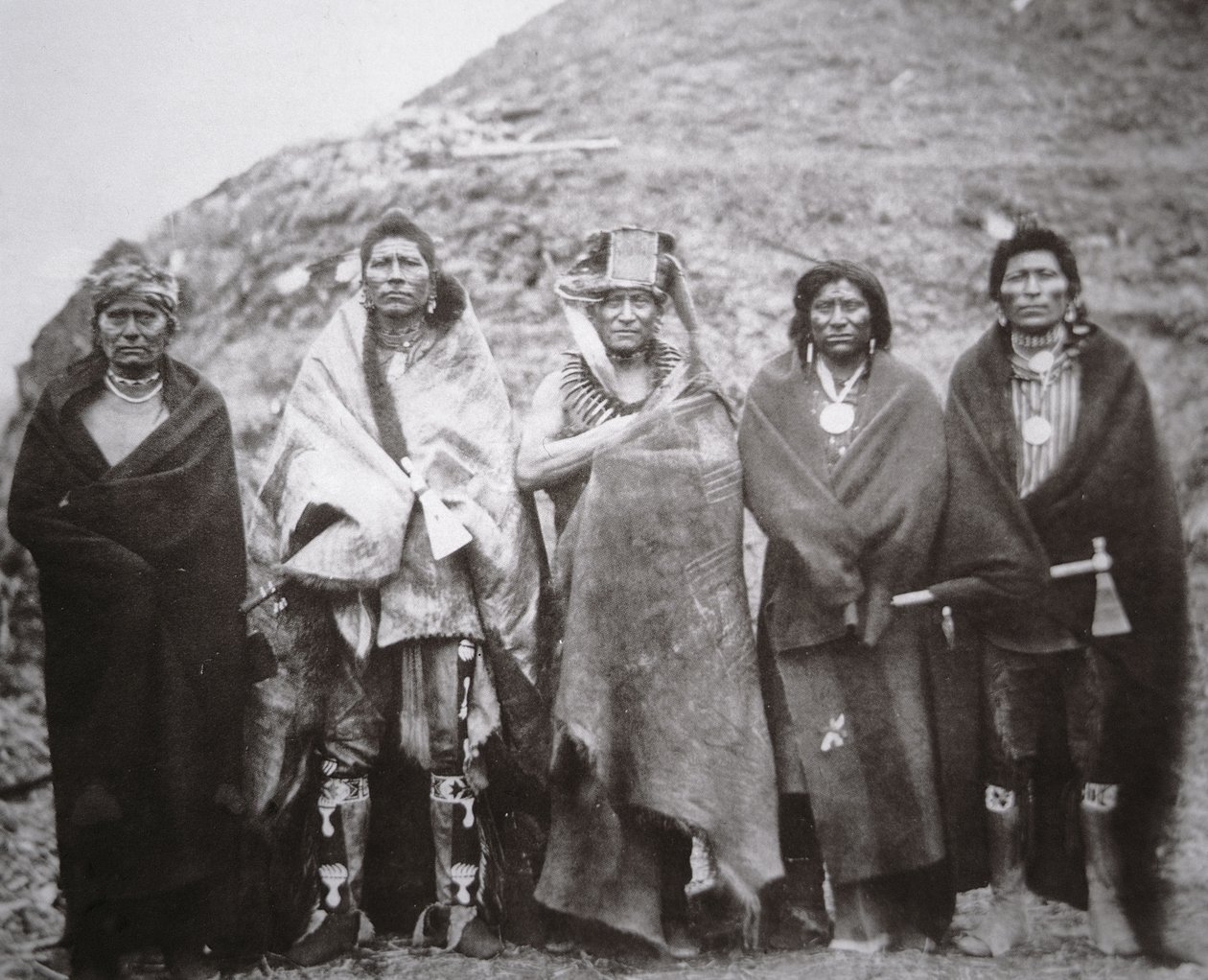 Pawnee people in front of a tribal earth lodge