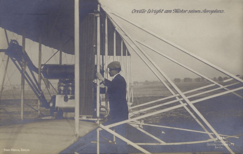 American aviator Orville Wright inspecting the engine of his aeroplane